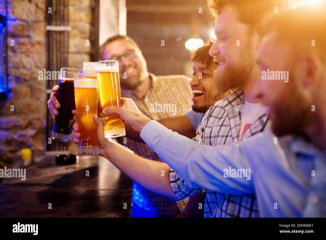 Fröhliche Gruppe von Freunden, die mit Bier vom Fass in der Bar feiern ...