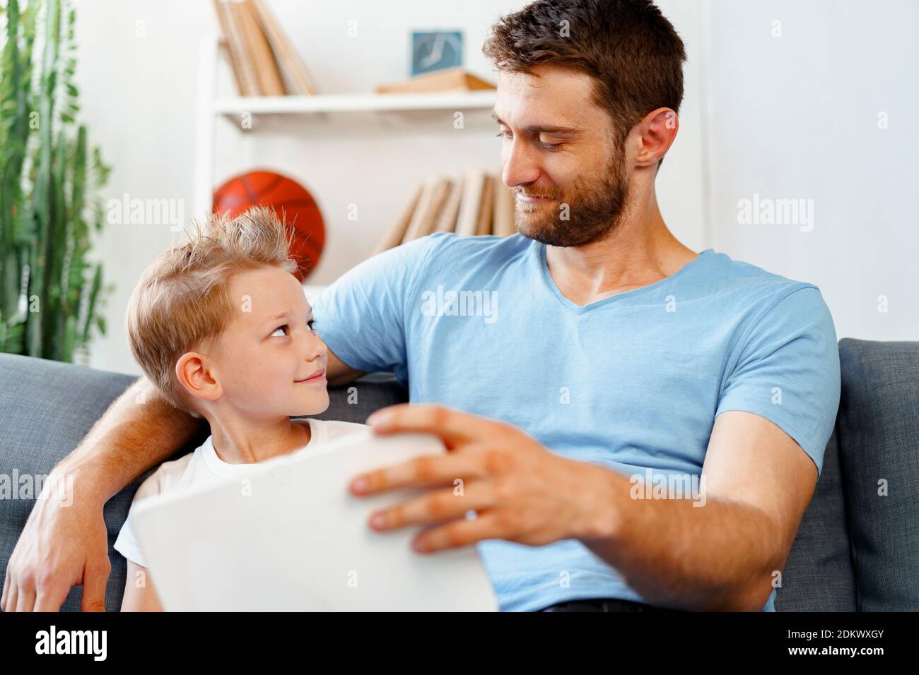 Kleiner Junge und sein Vater sehen sich Videos auf einem digitalen ...