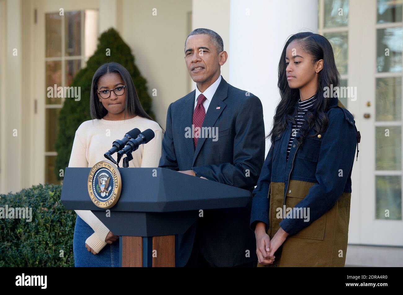 Präsident Barack Obama spricht, während die Töchter Sasha und Malia ...