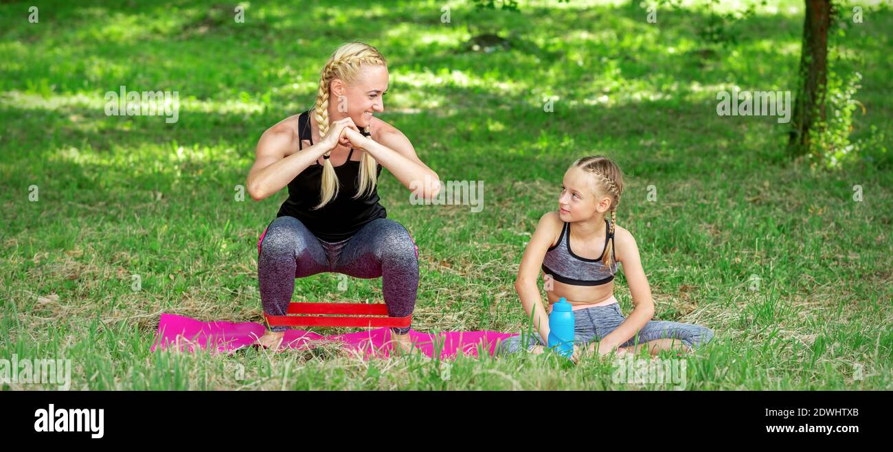 Mutter und Tochter machen Sportübungen auf der Matte in Der Park im ...
