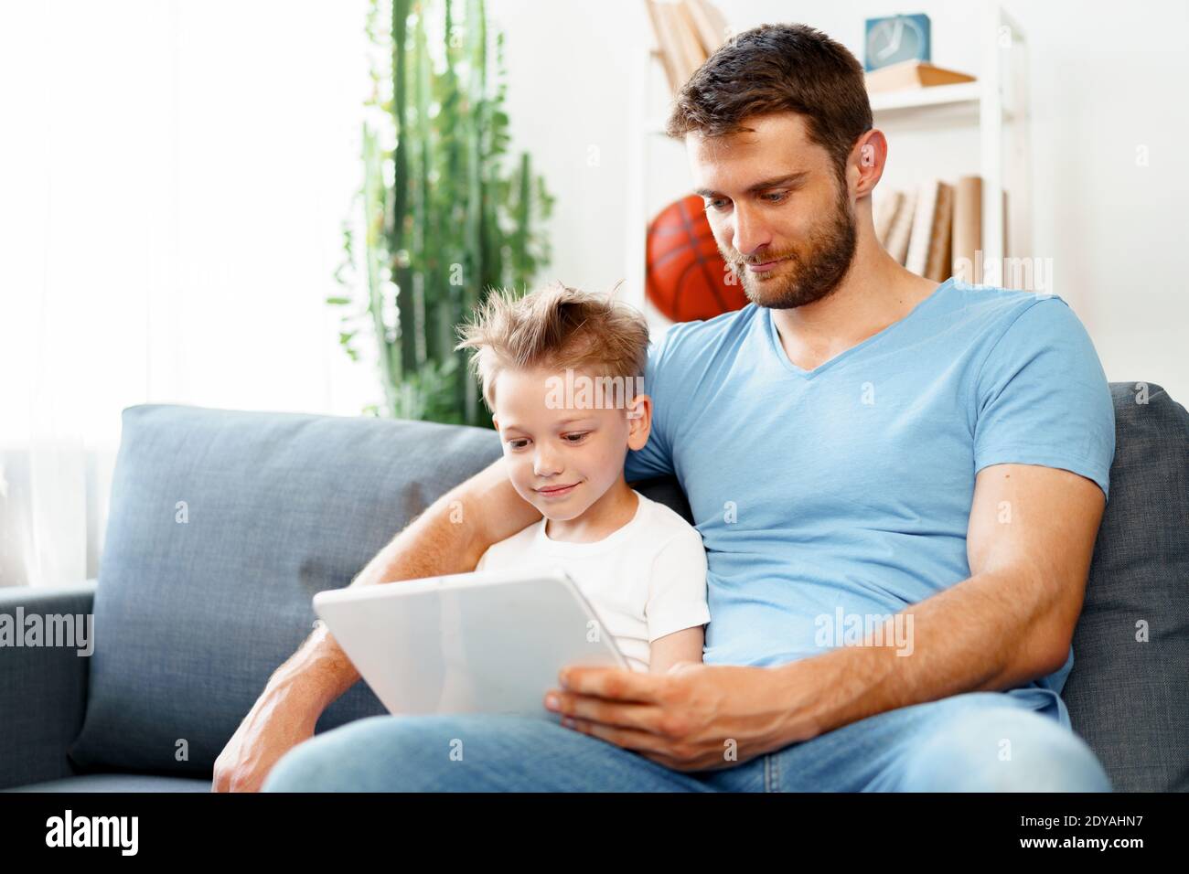Kleiner Junge und sein Vater sehen sich Videos auf einem digitalen ...