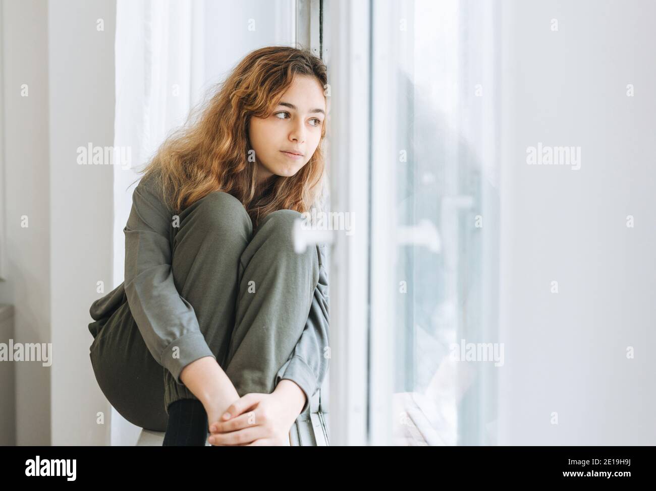 Schöne traurige unglückliche Teenager-Mädchen mit lockigen Haaren ... Schöne traurige unglückliche Teenager-Mädchen mit lockigen Haaren ...