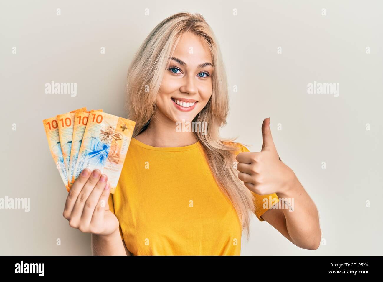 Schöne kaukasische blonde Mädchen hält 10 schweizer Franken Banknoten ... Schöne kaukasische blonde Mädchen hält 10 schweizer Franken Banknoten ...