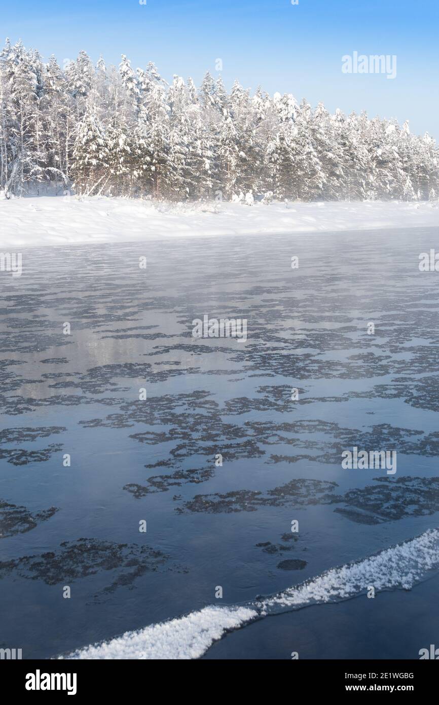 Frostiger Nebel über dem Winterfluss mit Schnee und Wald am Ufer ...
