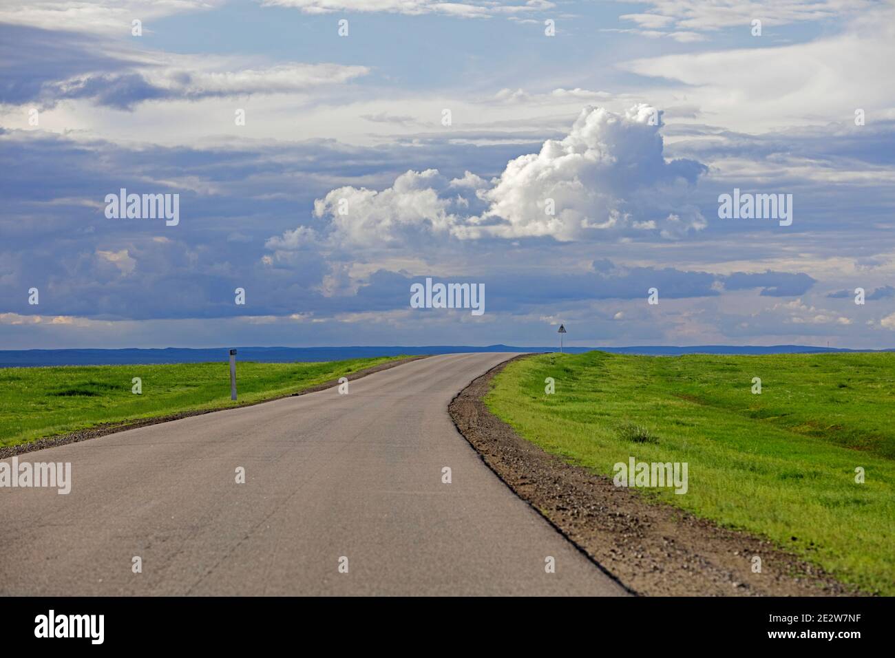 Leere Straße und Regenwolken bilden sich über der Wüste Gobi ...