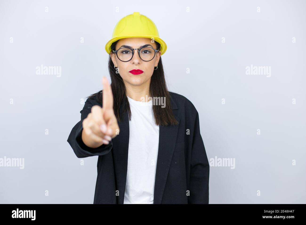 Junge Architektin Frau trägt Hardhat zeigen und zeigen mit Finger ...