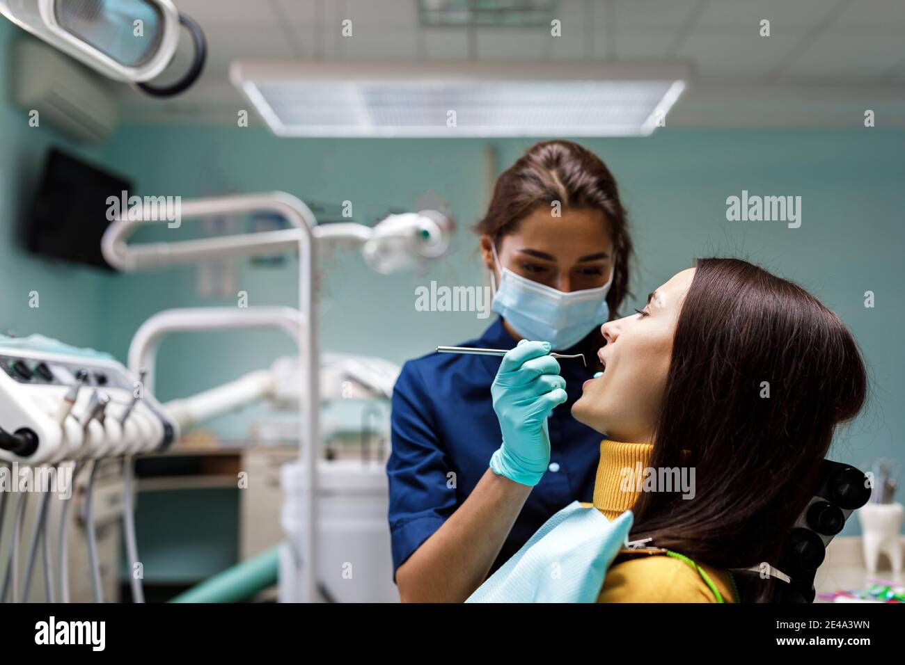Die schöne junge Frau ist beim Zahnarzt. Sie sitzt auf dem Zahnarztstuhl und der Zahnarzt ...