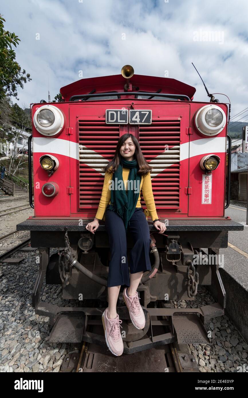 Wunderschöne Touristenpose mit rotem Zug an der Haltestelle der Alishan ...