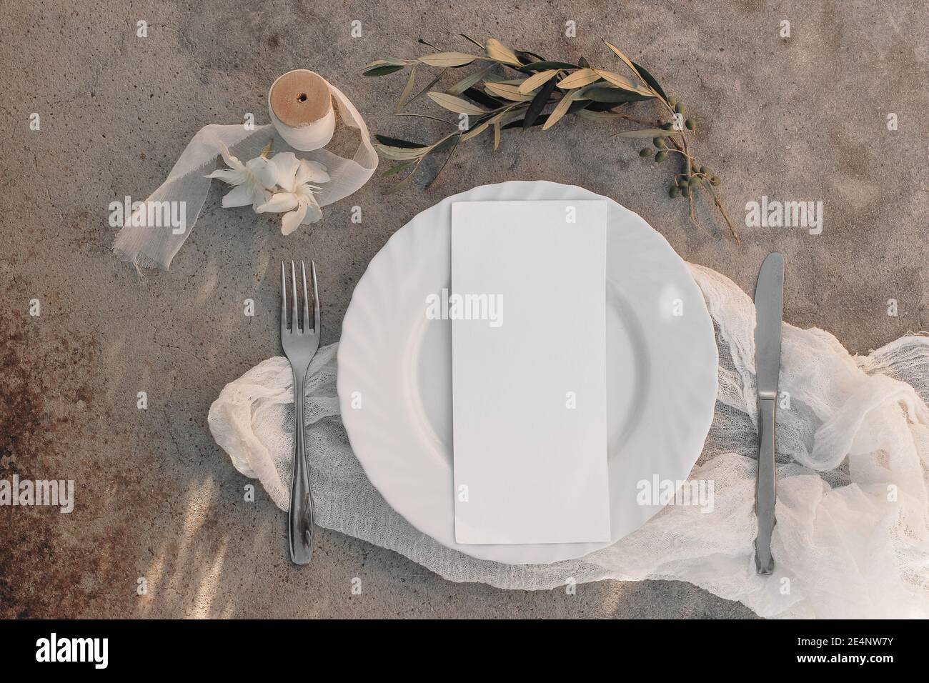 Festlicher Sommer-Rahmen mit silbernem Besteck, Olivenzweig und Teller ...