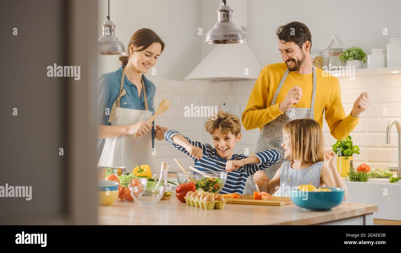 In der Küche: Vierköpfige Familie Kochen zusammen gesundes Abendessen ...