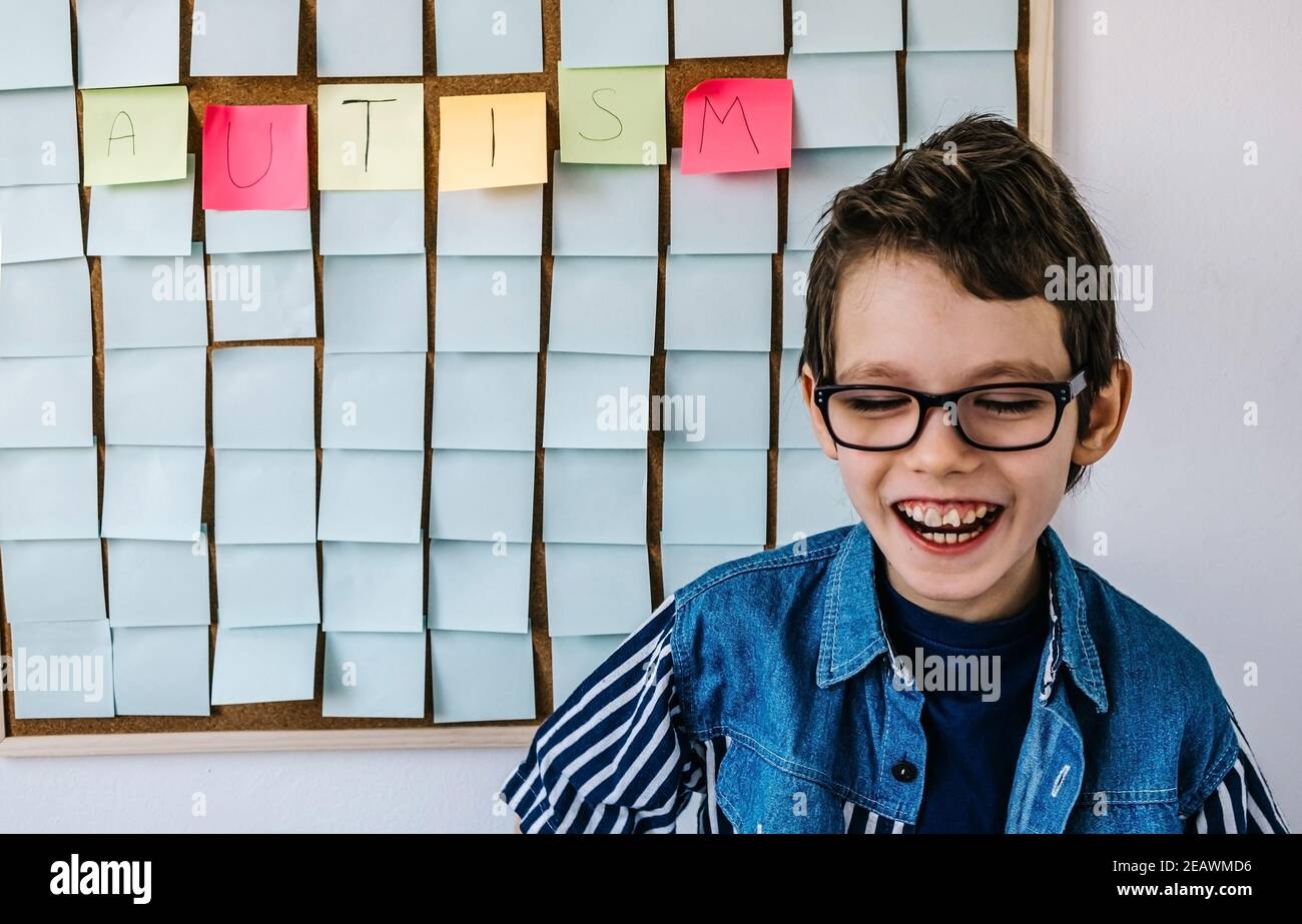 Portrait von fröhlichen Autismus Junge mit Brille in blauem Hemd vorne ...