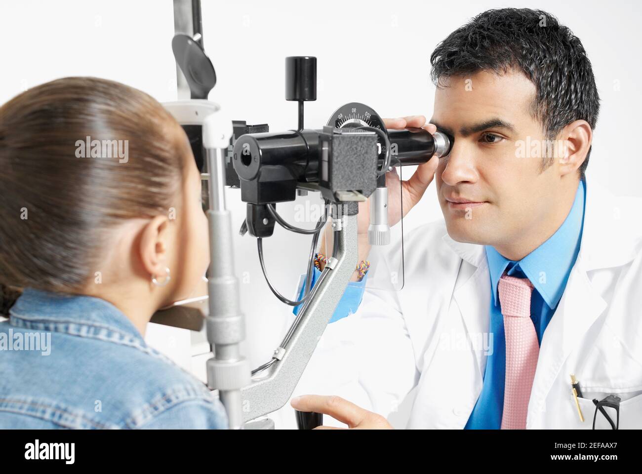 Augenoptiker, der ein girlÅ½s Auge untersucht Stockfotografie - Alamy