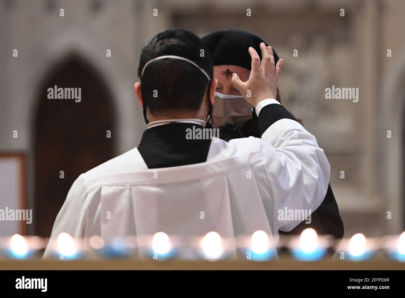 Ein Seminarist legt Asche auf die Stirn eines Kirchenbesuchers in der ...