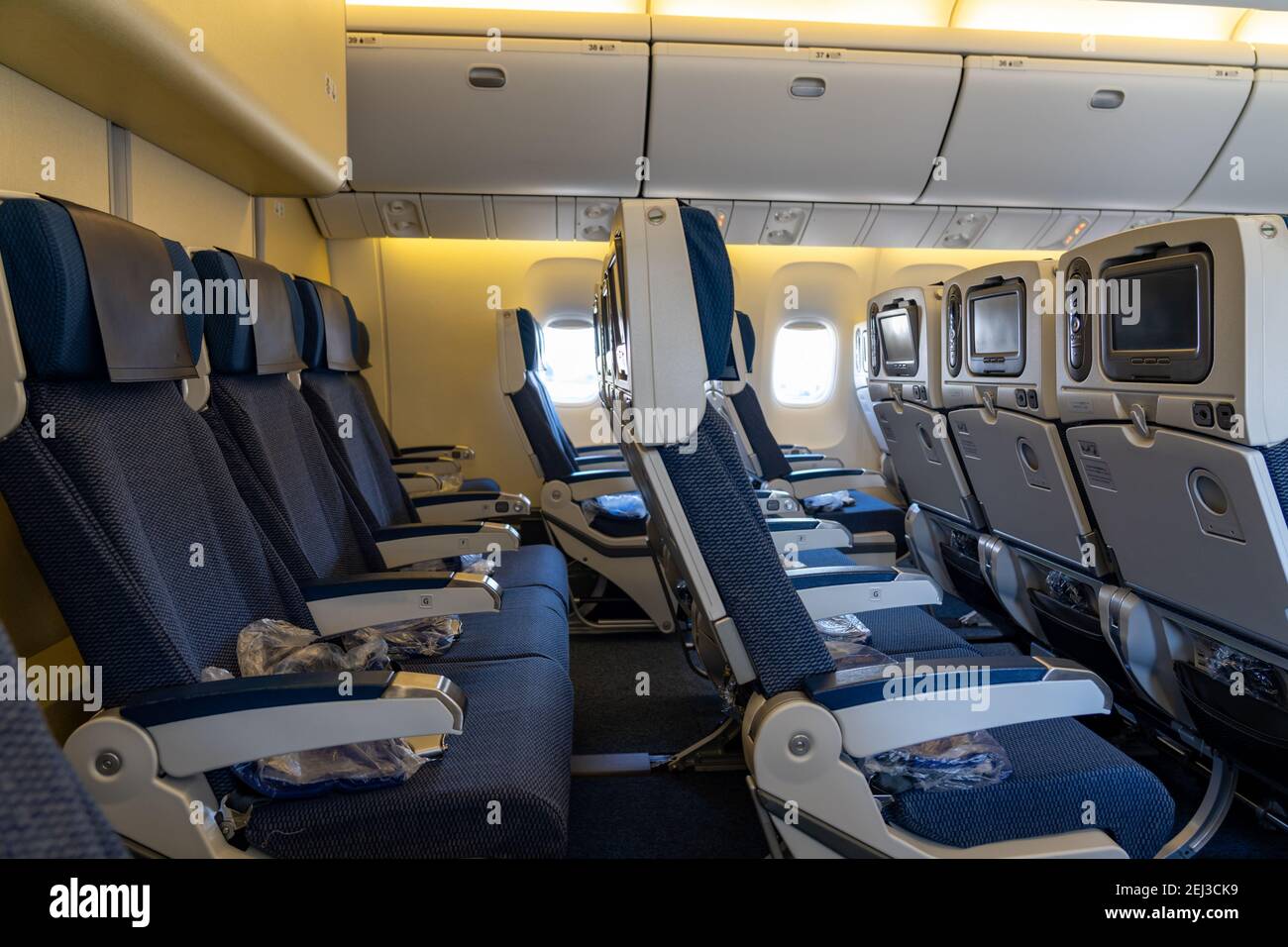 Sitze in der Economy-Klasse der Flugzeugkabine mit Touchscreen ...