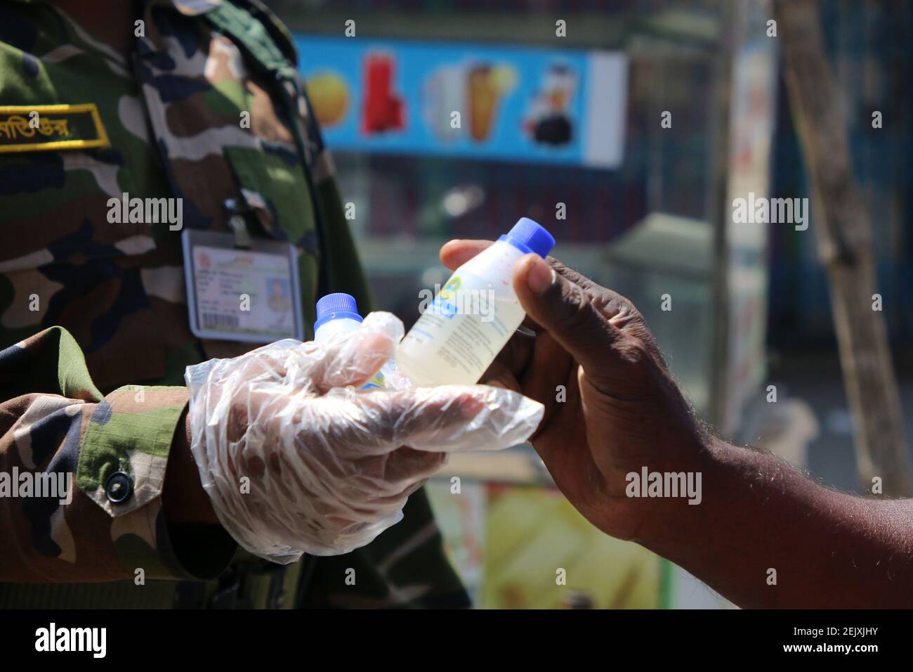 Ein Soldat der Armee verteilt Handdesinfektionsmittel an die Armen, da er besorgt über die ...