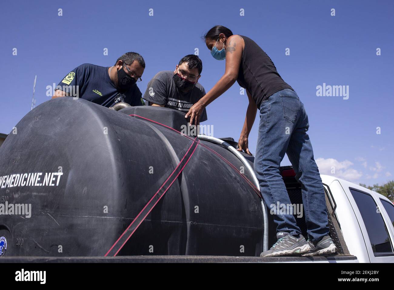 Von links: Jeremy Begay, Eric Teller und Deborah Tso füllen einen Tank ...