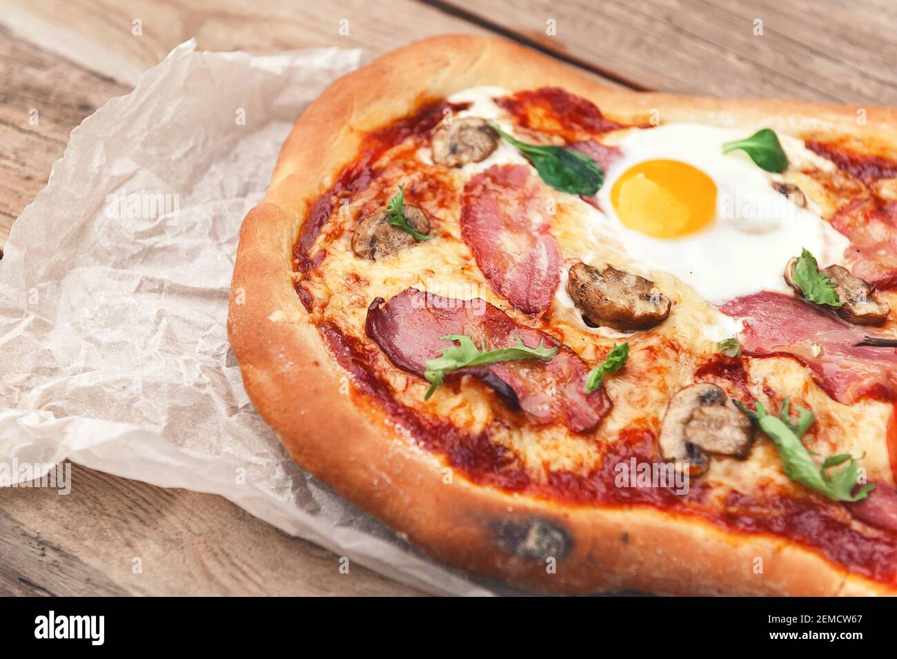 Frische leckere Pizza aus dem Ofen mit Ei, Schinken und Tomate ...