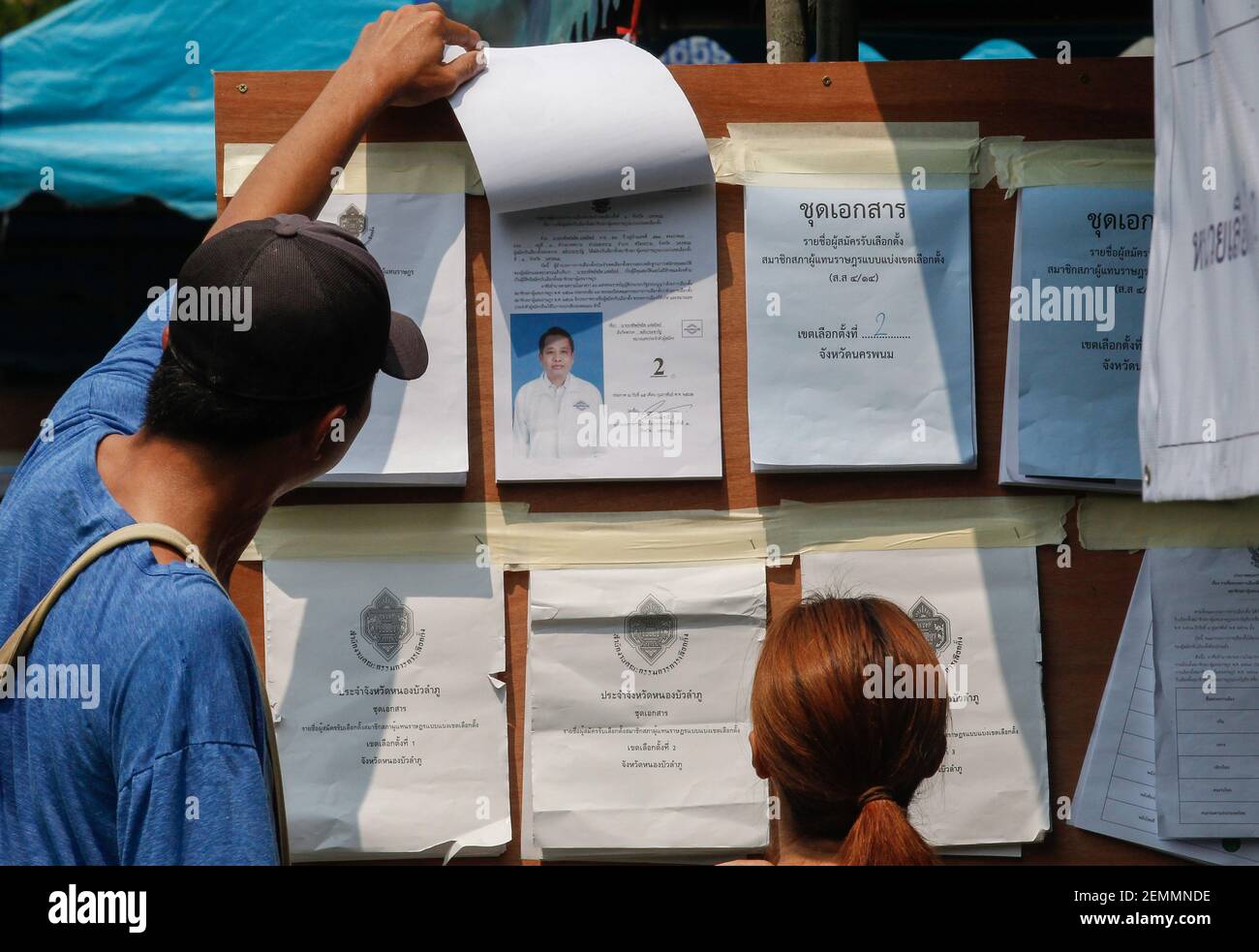 Ein Mann schaut auf ein Board mit Profilen von Kandidaten, bevor er vor ...