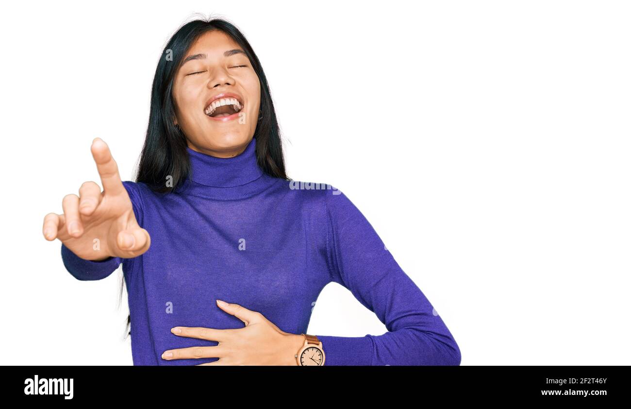 Schöne junge asiatische Frau trägt Freizeitkleidung lachend auf Sie, Zeigefinger auf die Kamera ...