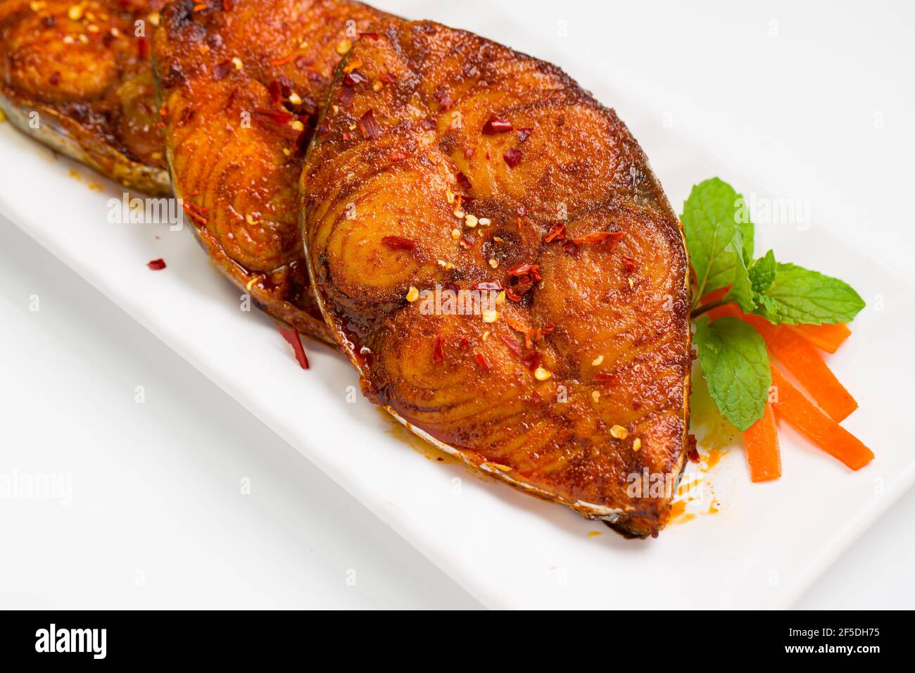 Seer Fisch braten schön angeordnet und garniert mit Zwiebeln, Zitronen ...
