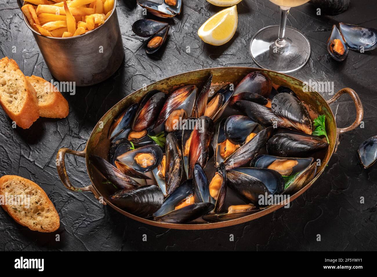 Moules Frites, Muscheln mit Pommes frites, mit Zitrone und Toast ...