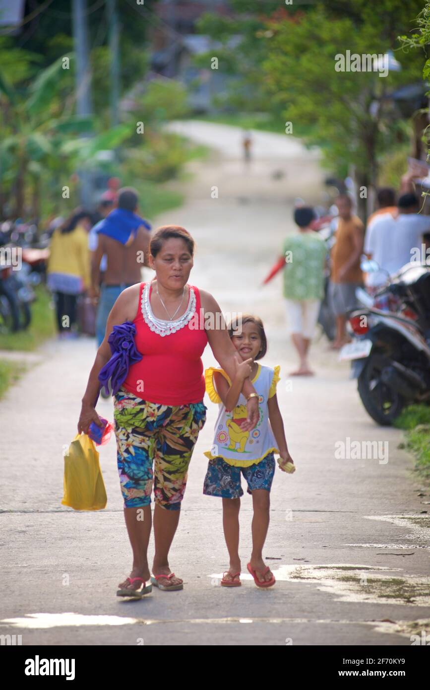 Filipina Mutter und Tochter, die auf der Straße spazieren, Camayaan ...