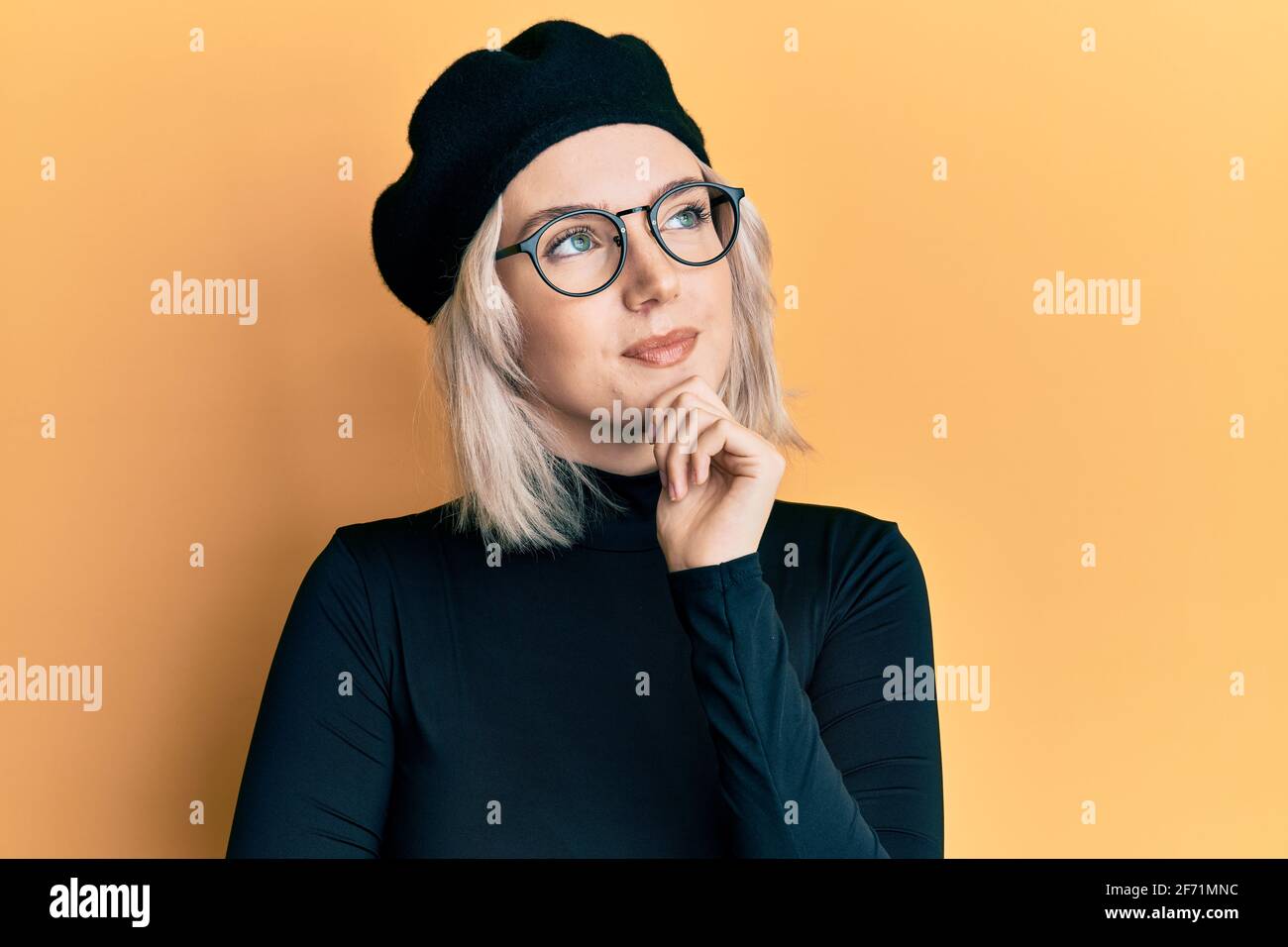 Junges blondes Mädchen im französischen Look mit Baskenmütze, das ... Junges blondes Mädchen im französischen Look mit Baskenmütze, das ...