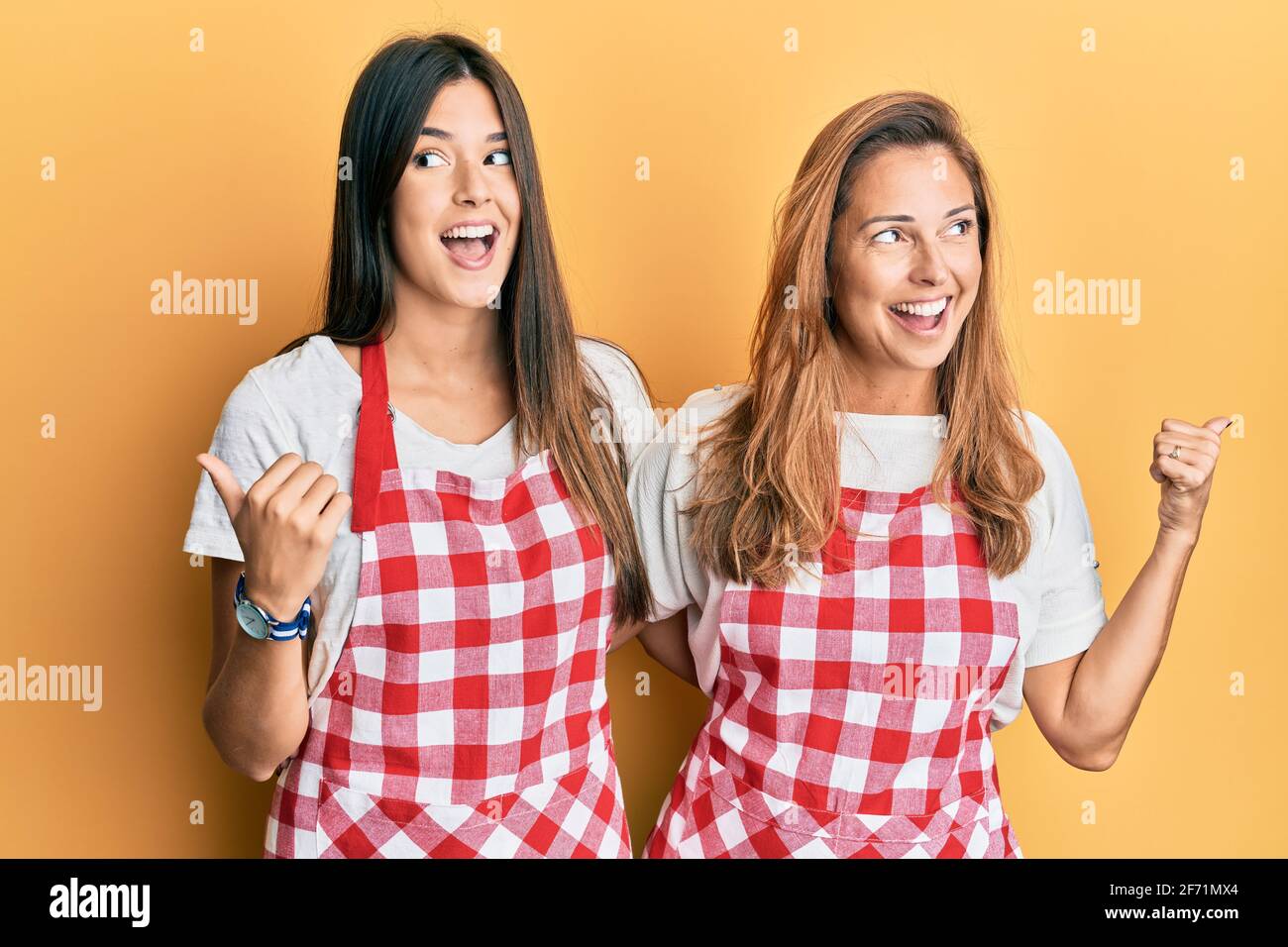 Hispanische Familie von Mutter und Tochter trägt Bäckeruniform über ... Hispanische Familie von Mutter und Tochter trägt Bäckeruniform über ...