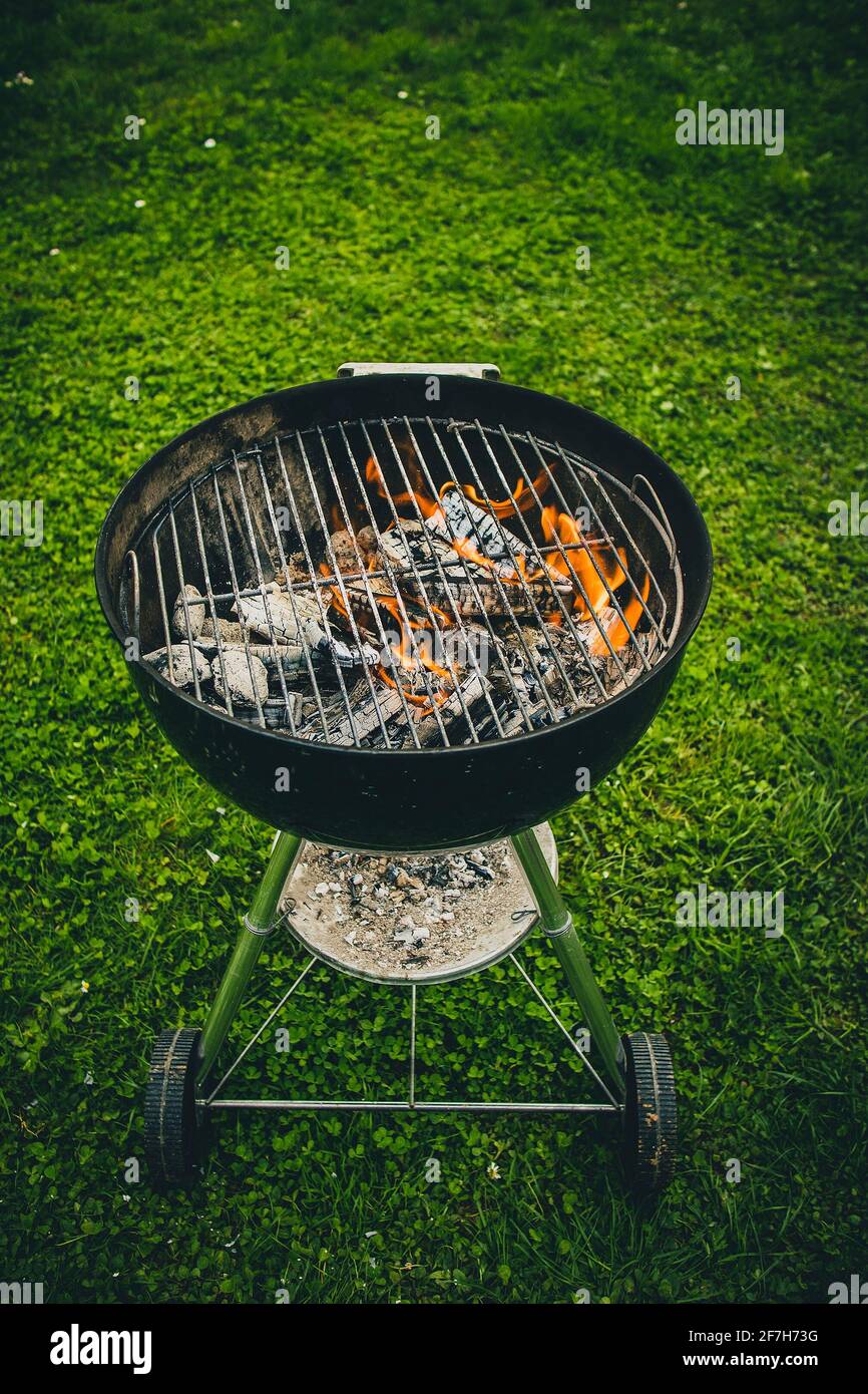 Runder mobiler Grill oder Grill auf einer grünen Fläche oder Rasen ...