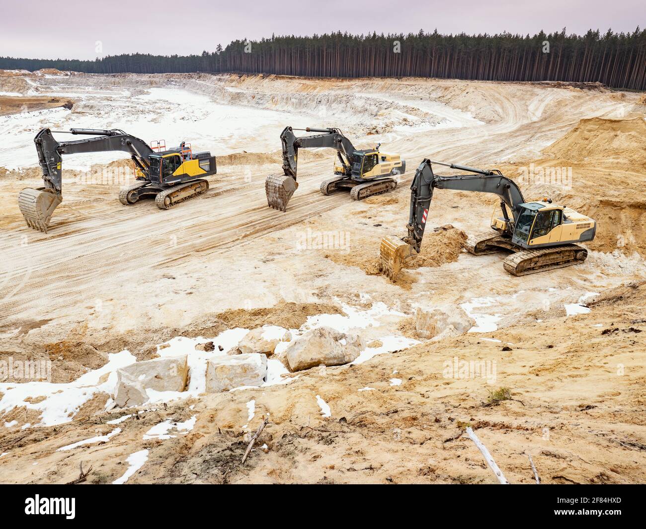 Gleisbagger in großen Steinbruch mit weißem Sand. Baggerlader-Maschine ...