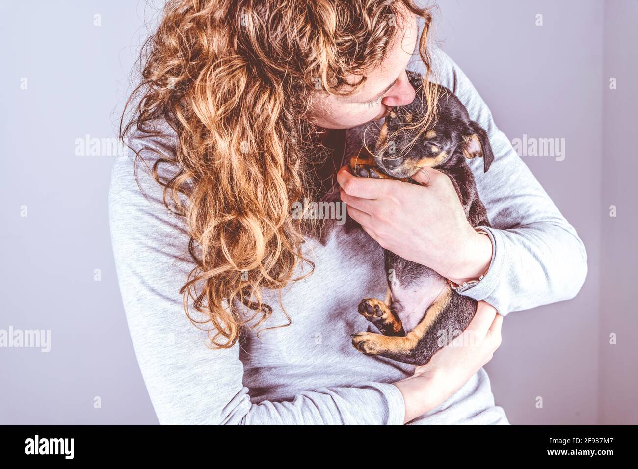 Als Teil einer Frau mit braunen Locken küsst sie liebevoll einen ...