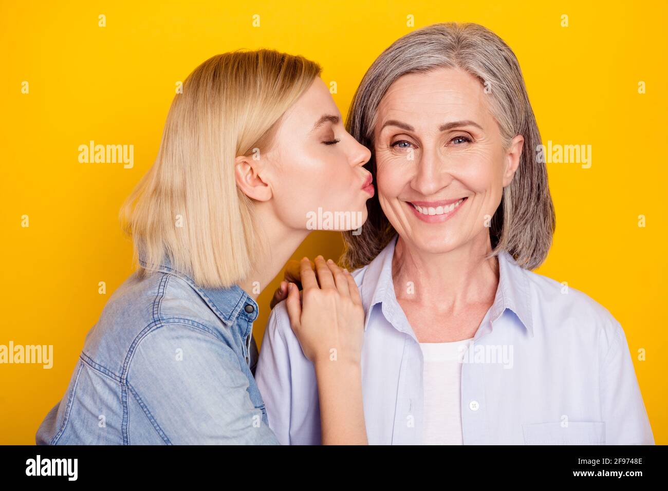 Fotoportrait der Tochter, die ihre schöne Mutter küsst und isoliert ...