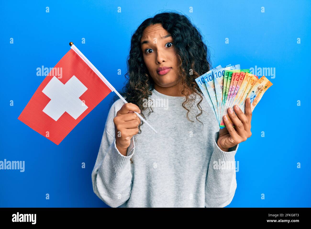 Junge lateinerin mit Schweizer Flagge und schweizer Franken-Banknoten ... Junge lateinerin mit Schweizer Flagge und schweizer Franken-Banknoten ...