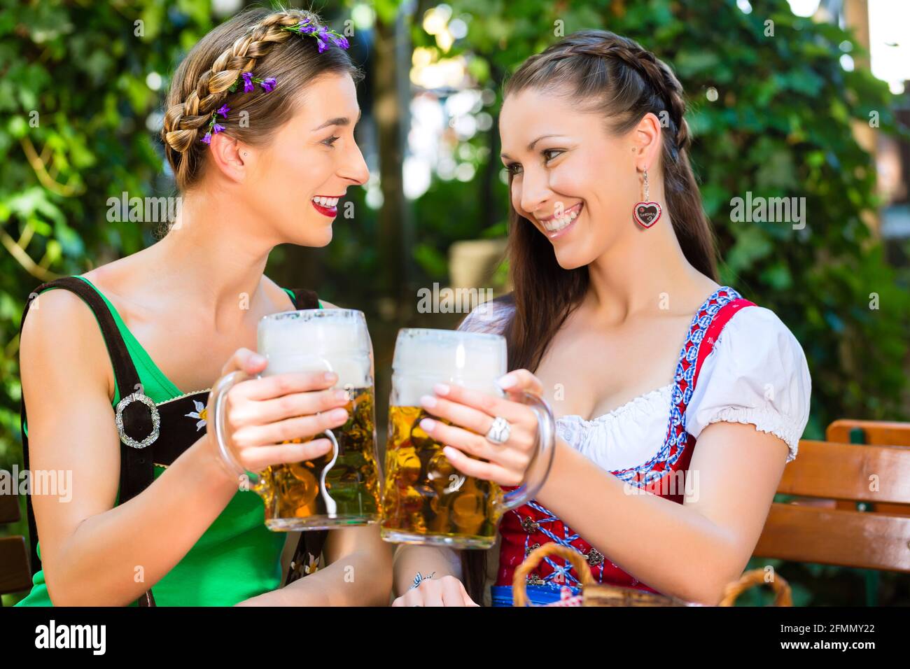 Im Biergarten – Freundinnen in Tracht, Dirndl und Lederhosen ein ...