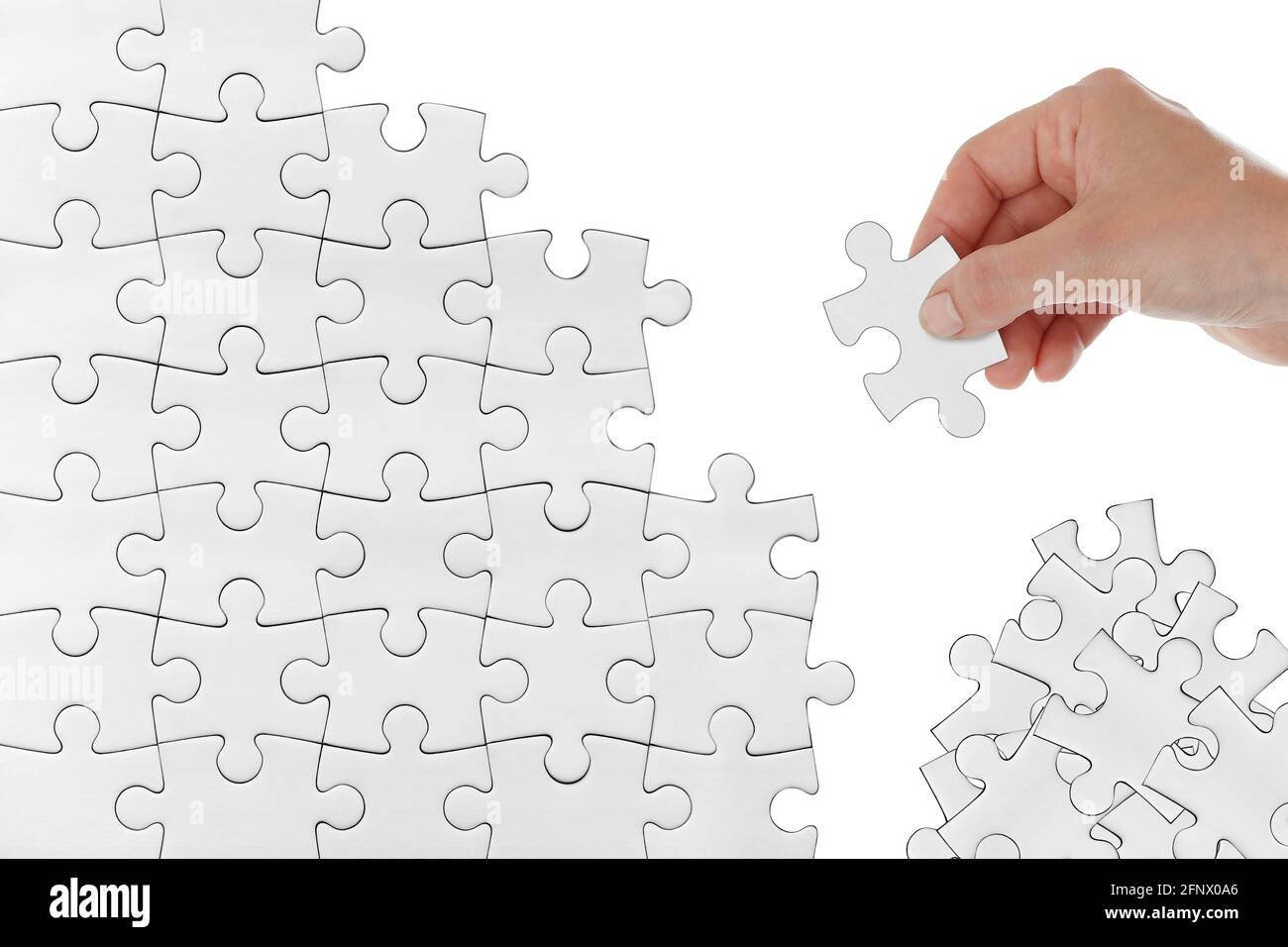 Menschliche weibliche Hand versucht, weiße Puzzleteile Kommissionierung ...