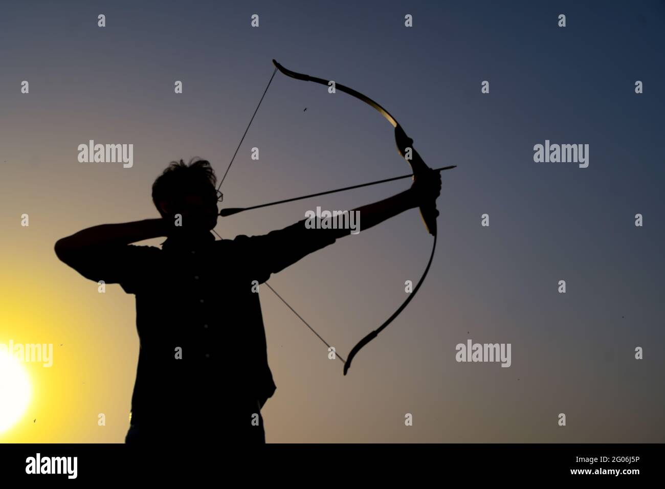 Ein Mann mit Silhouetten, der einen Pfeil und einen Bogen vor einem ...