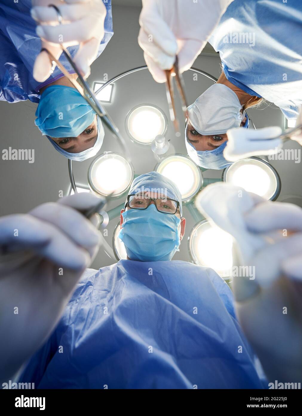 Blick von unten auf Ärzte, die Skalpell, Schere und Zangenzelle mit ...