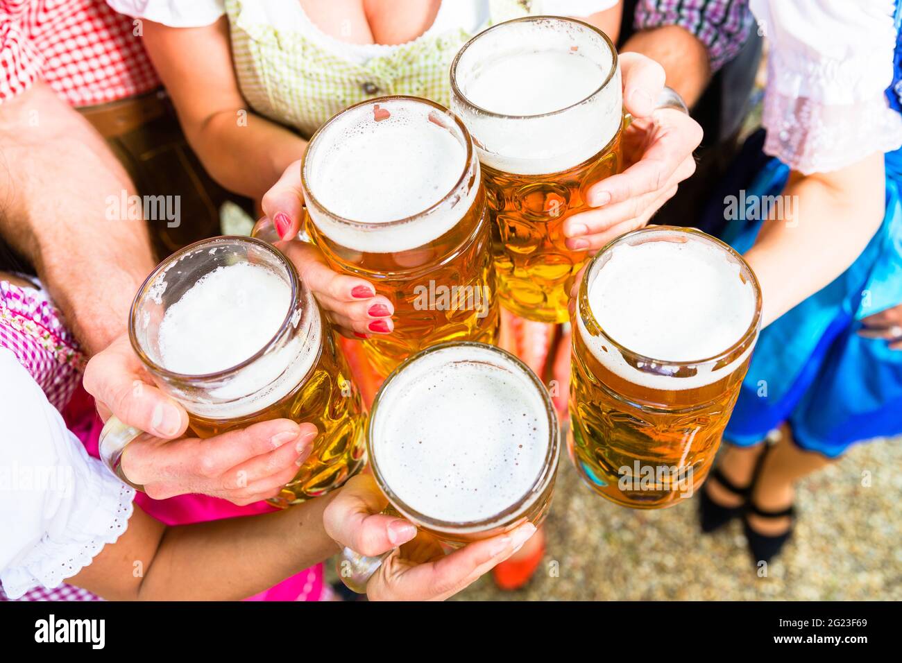 Anstoßen mit einem Bier in der Bayerischen Biergarten, close-up auf ...