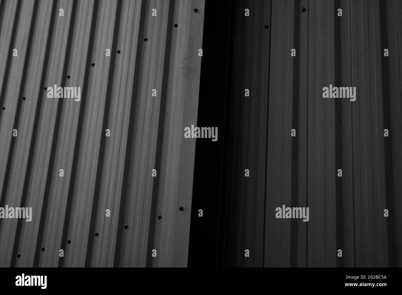 Schwarzes Wellblech, das als Fassade eines Lagers oder einer Fabrik ...