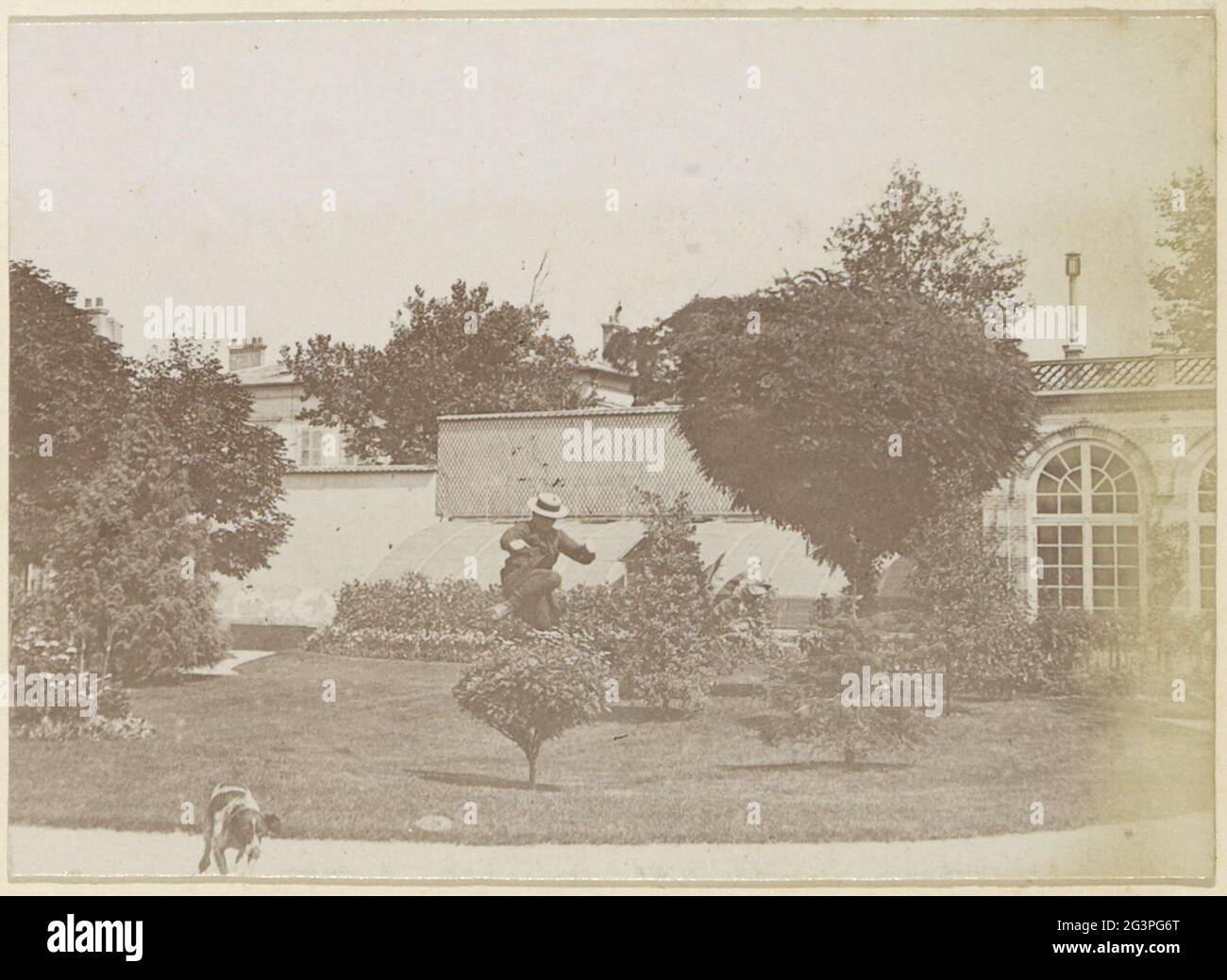 Der Mensch springt in einem Garten in Frankreich über einen Busch. Teil ...