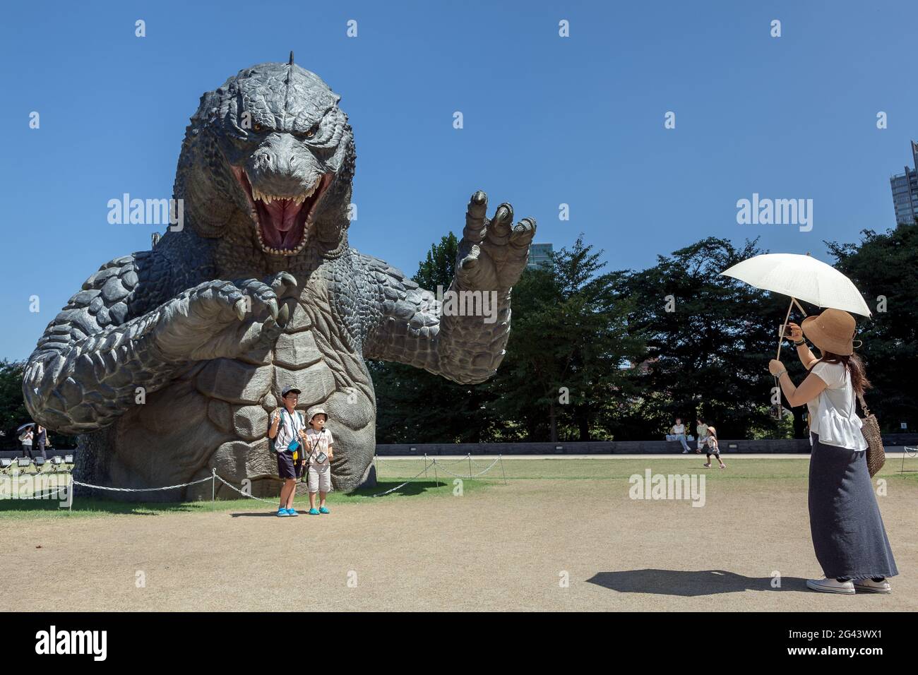 Eine Japanerin fotografiert ihre Kinder vor einem großen Modell von ...