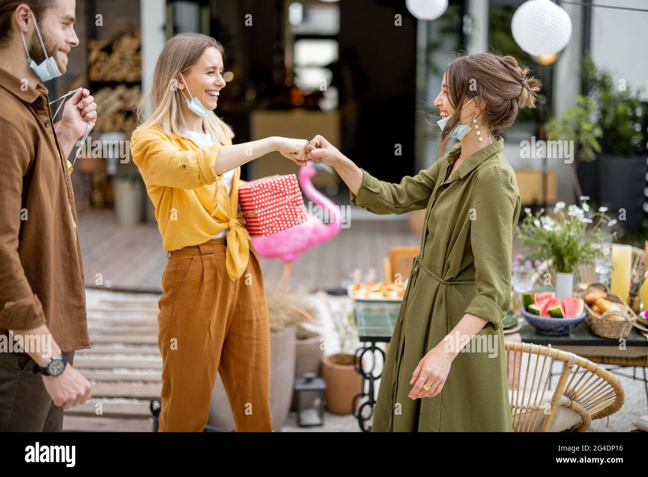 Junge Erwachsene Freunde treffen sich zur Geburtstagsfeier im Hinterhof ...
