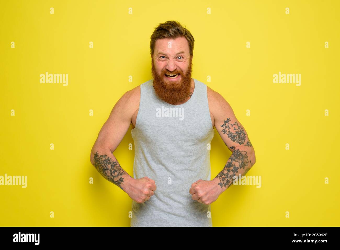 Mann mit Bart und Tattoos zeigt mit Stolz seine Muskeln Stockfotografie - Alamy