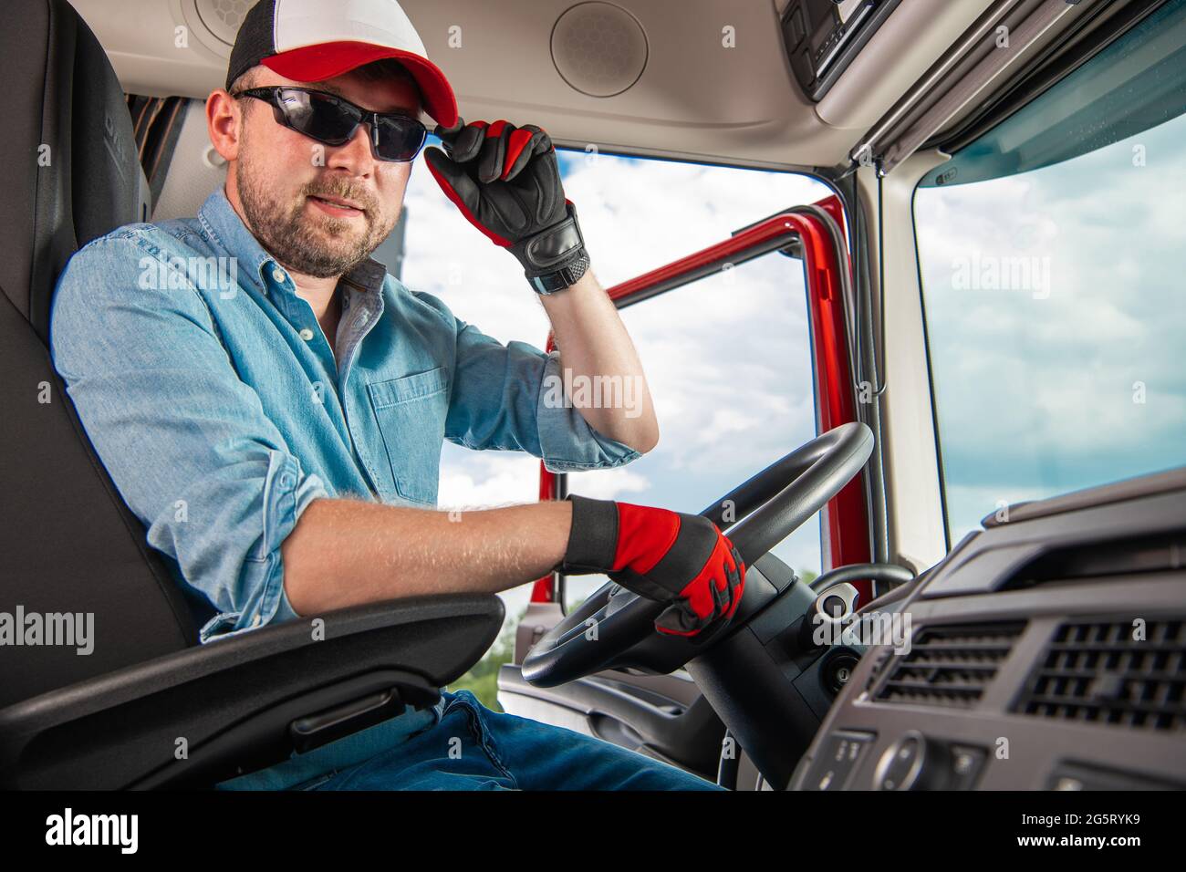Junger und zufriedener kaukasischer Semi-Truck-Fahrer in seinen 30er ...