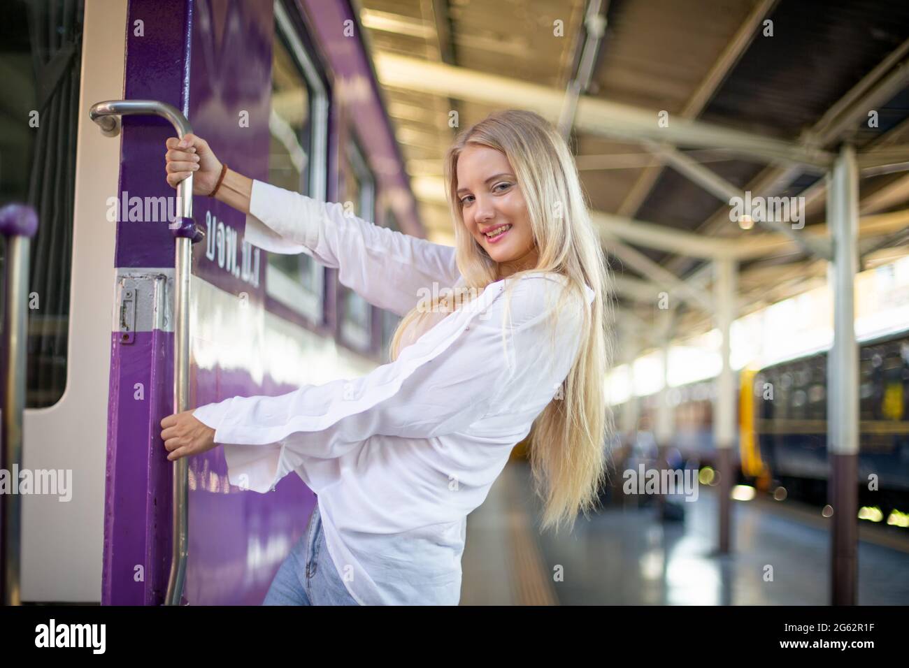 Junge Frau wartet im Vintage-Zug, entspannt und unbeschwert am Bahnsteig in Bangkok, Thailand ...