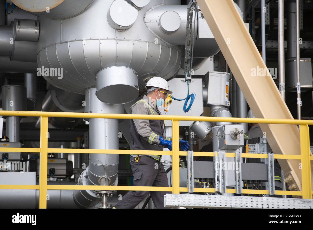 Außenansicht der Polyamid 12-Anlage, ein Arbeiter geht vorbei ...