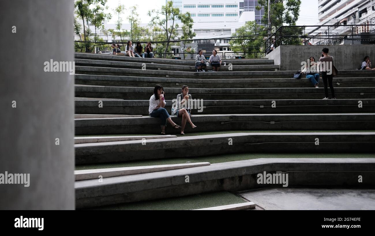Studenten sitzen entspannt im Einkaufszentrum Amphitheater auf ...