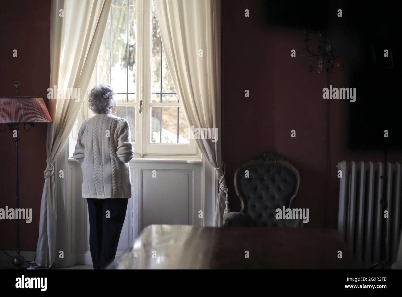 Alte frau schaut aus dem fenster -Fotos und -Bildmaterial in hoher ...
