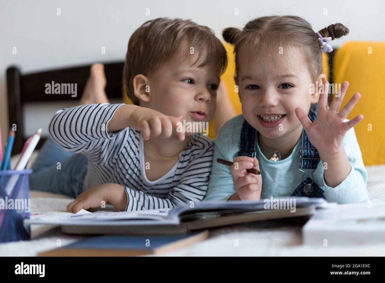 Smart lächelnd Vorschool Kleinkind Kinder Junge und Mädchen zeichnen mit Bleistiften liegen auf ...