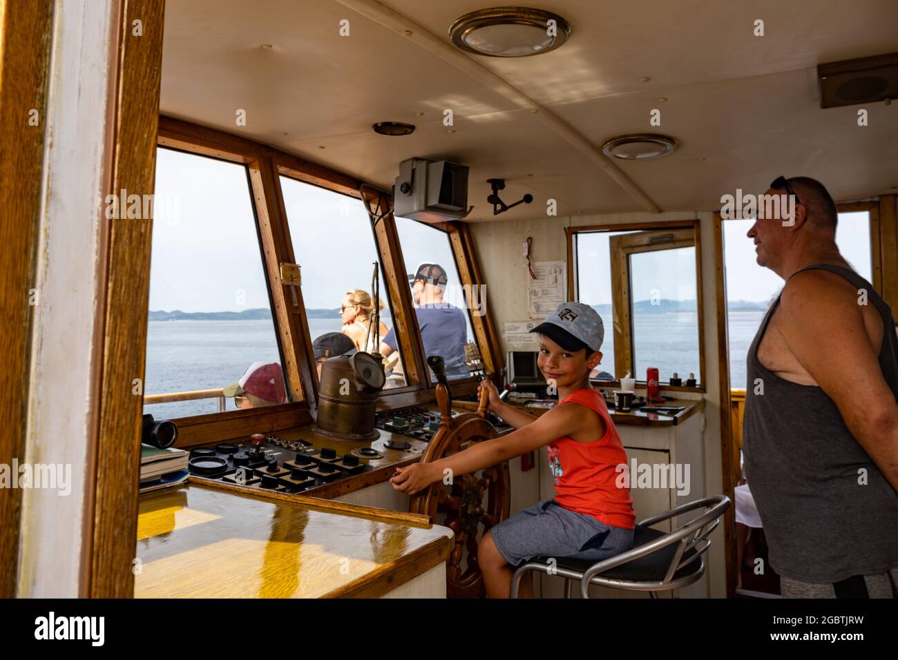 KORNATI, KROATIEN - 08. Jul 2021: Ein Kapitän zeigt dem Jungen das ...